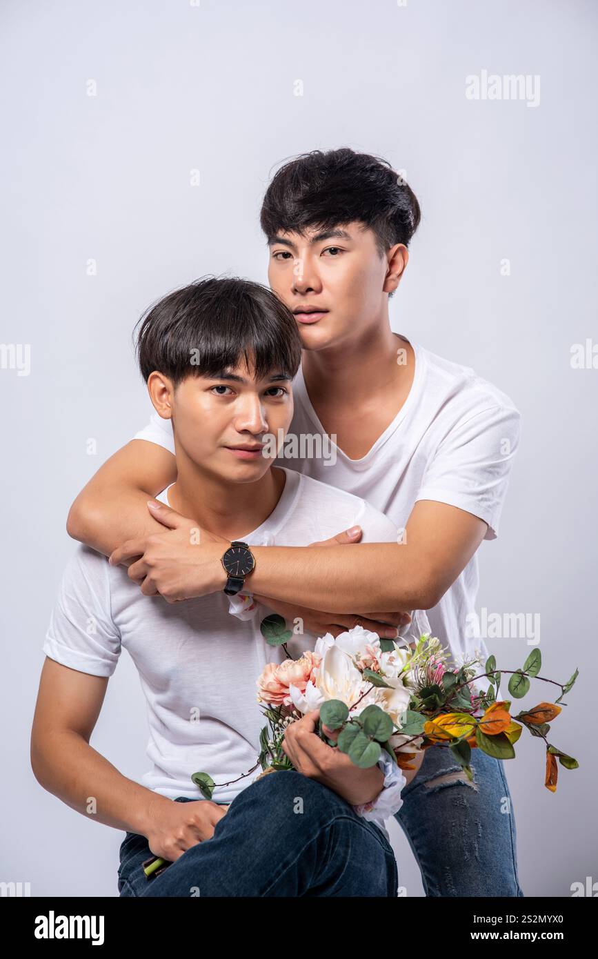 Two men who love each other hug from behind another Stock Photo - Alamy