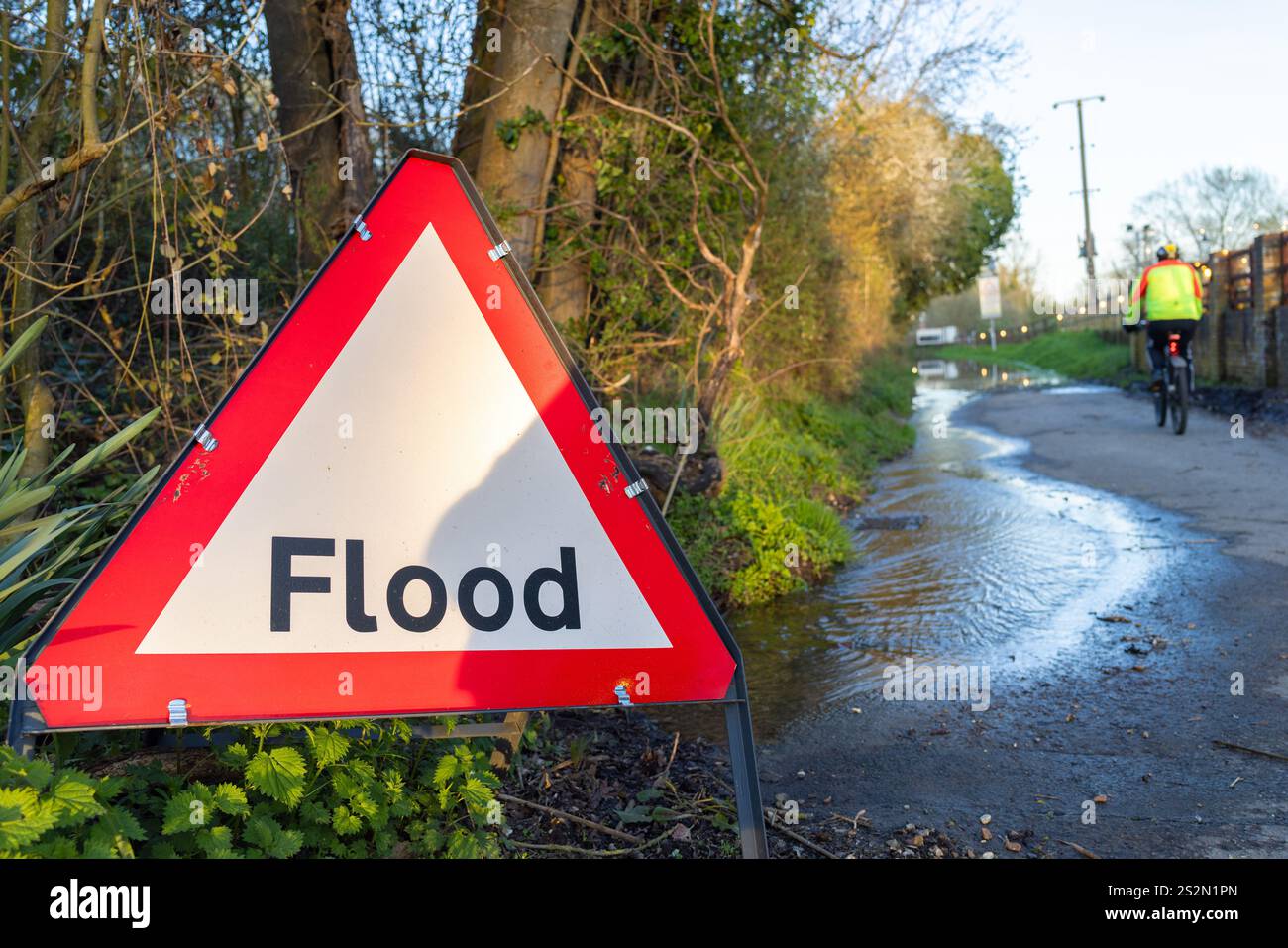 Flood Warning Sign With a Cyclist on a Flooded Road in England, United ...