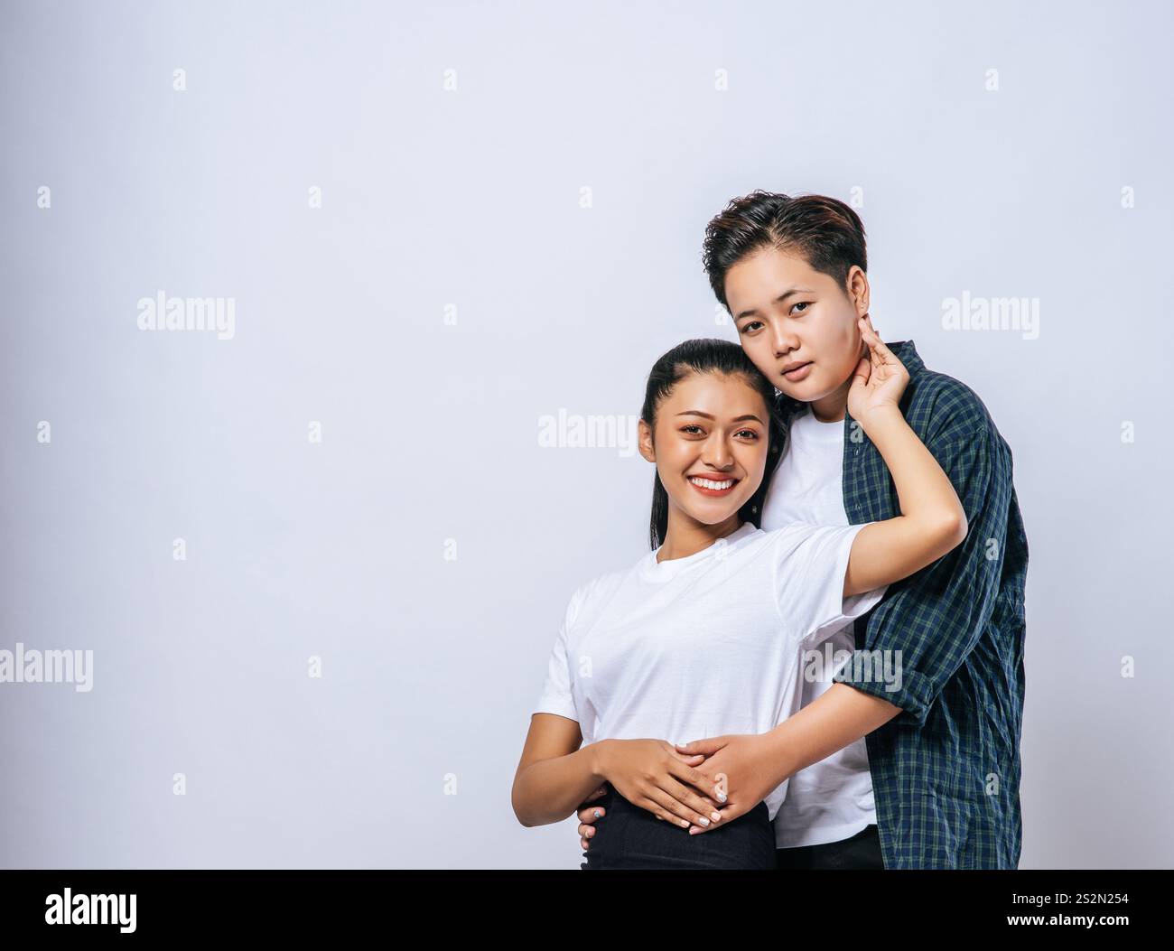 Two female lovers standing and hugging from behind Stock Photo - Alamy