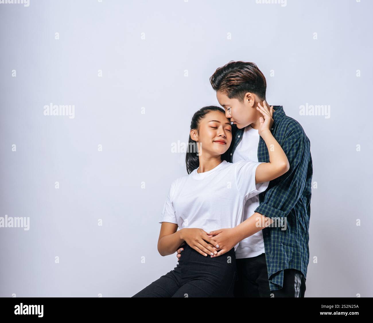 Two female lovers standing and hugging from behind Stock Photo - Alamy