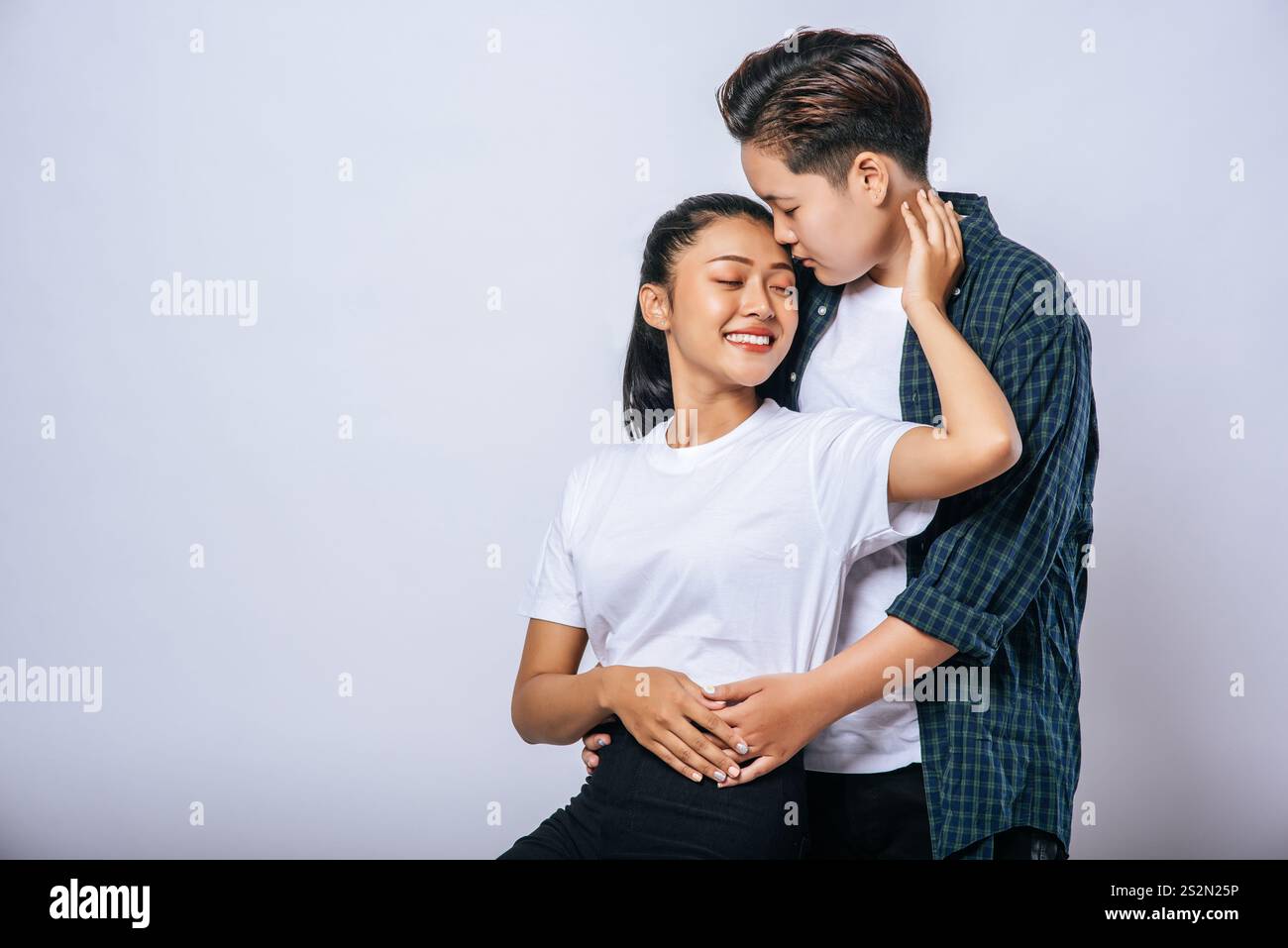 Two female lovers standing and hugging from behind Stock Photo - Alamy