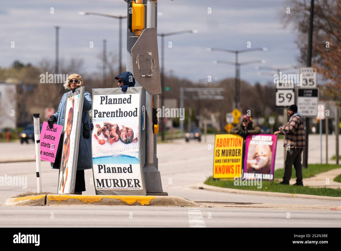Volunteers display pro-life signs at a busy intersection during an anti ...