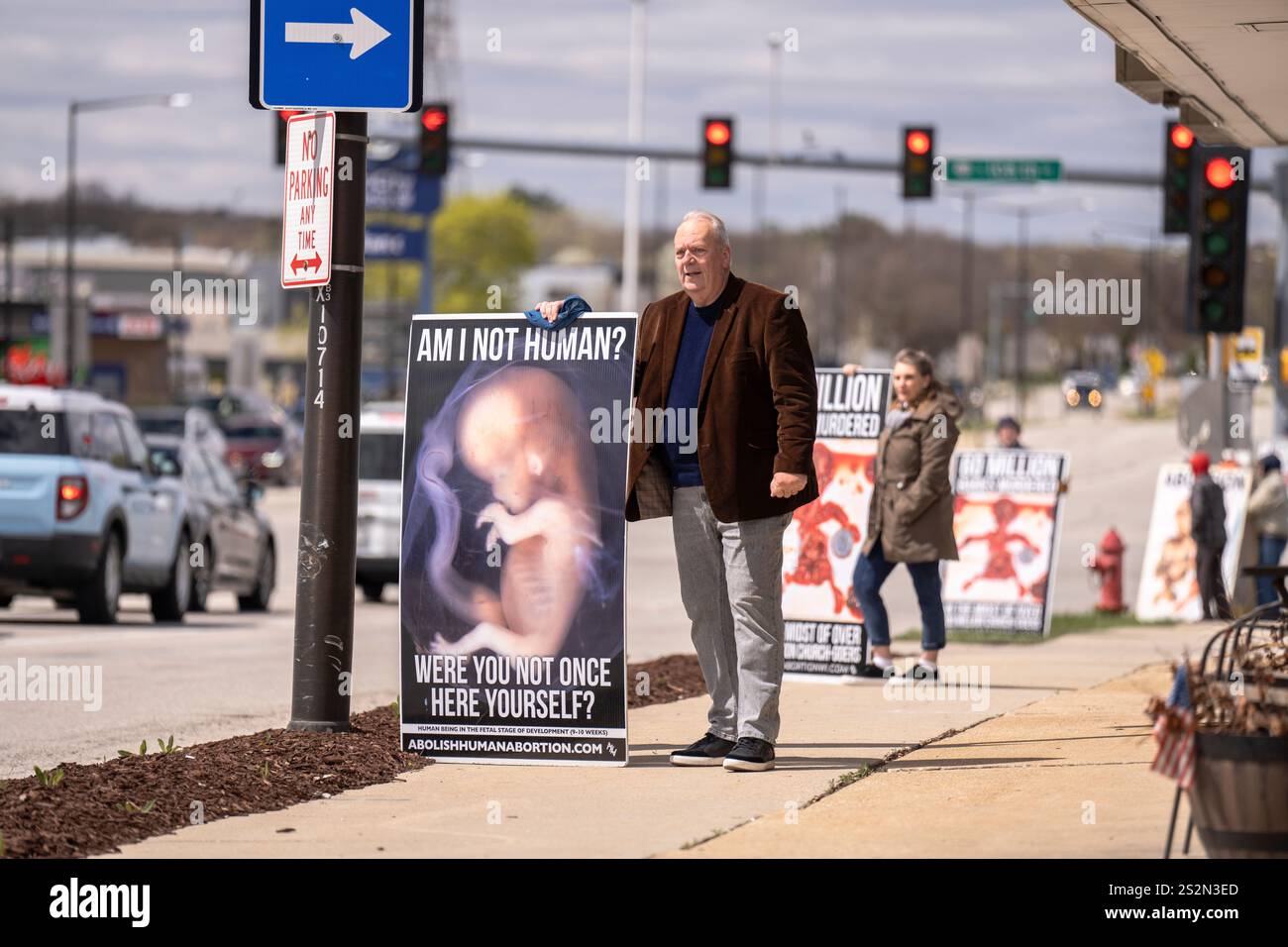 Volunteers display large pro-life signs at an anti-abortion street ...
