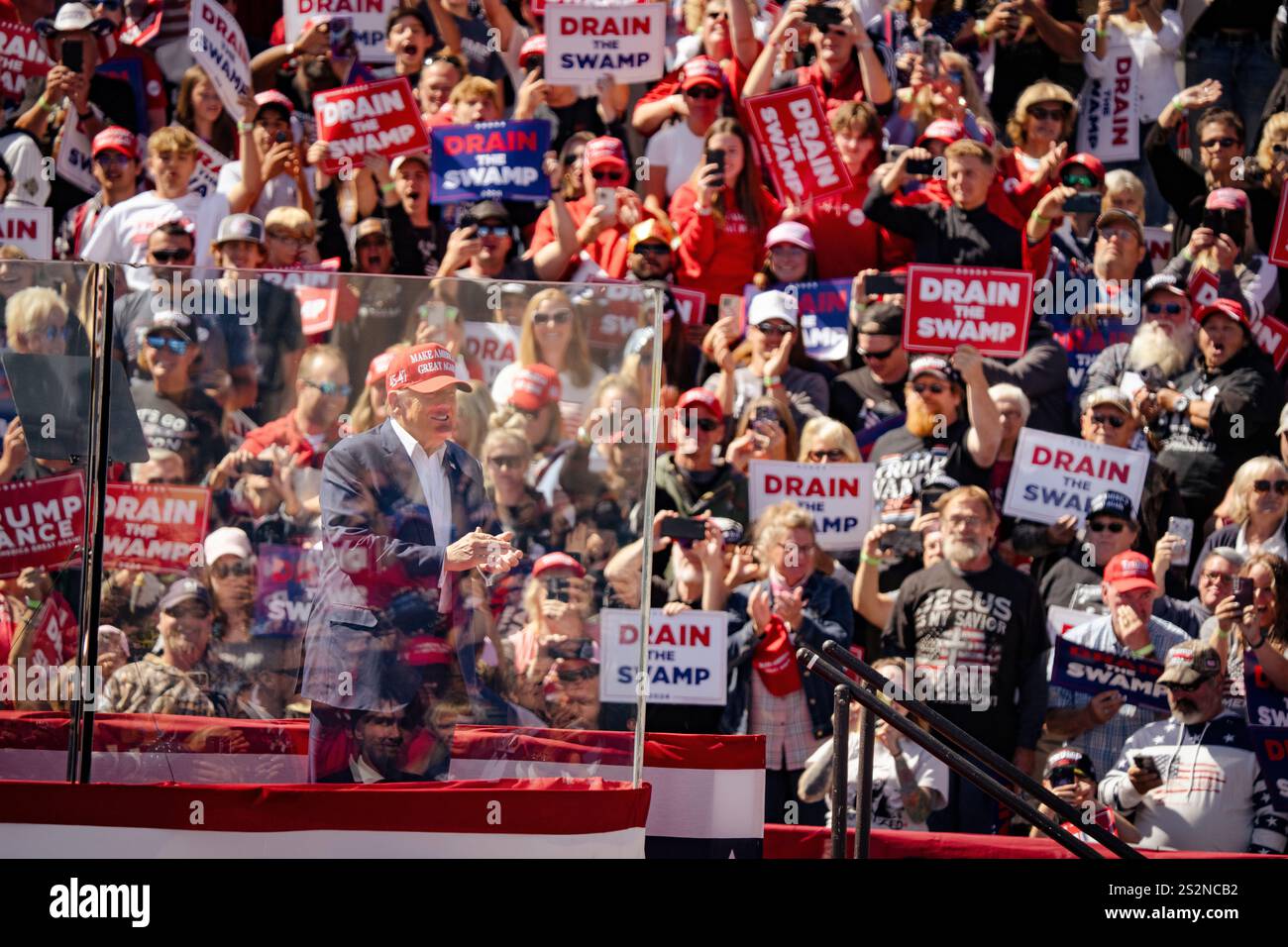 Donald Trump gives a speech behind bullet proof glass at a crowded ...