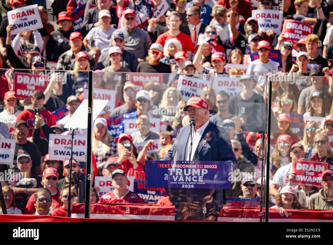 Donald Trump gives a speech behind bullet proof glass at a crowded ...