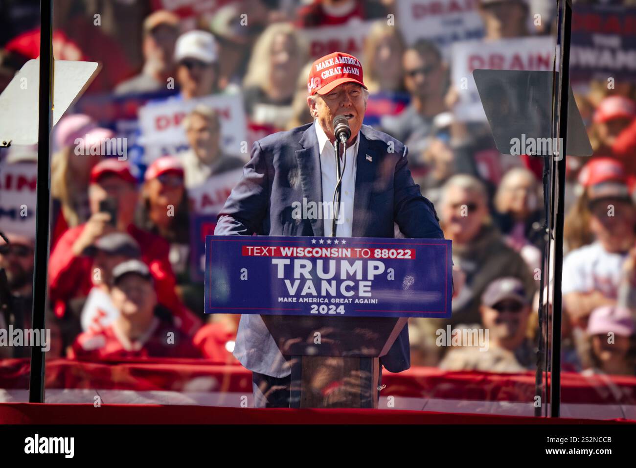 Donald Trump gives a speech behind bullet proof glass at an outdoor ...