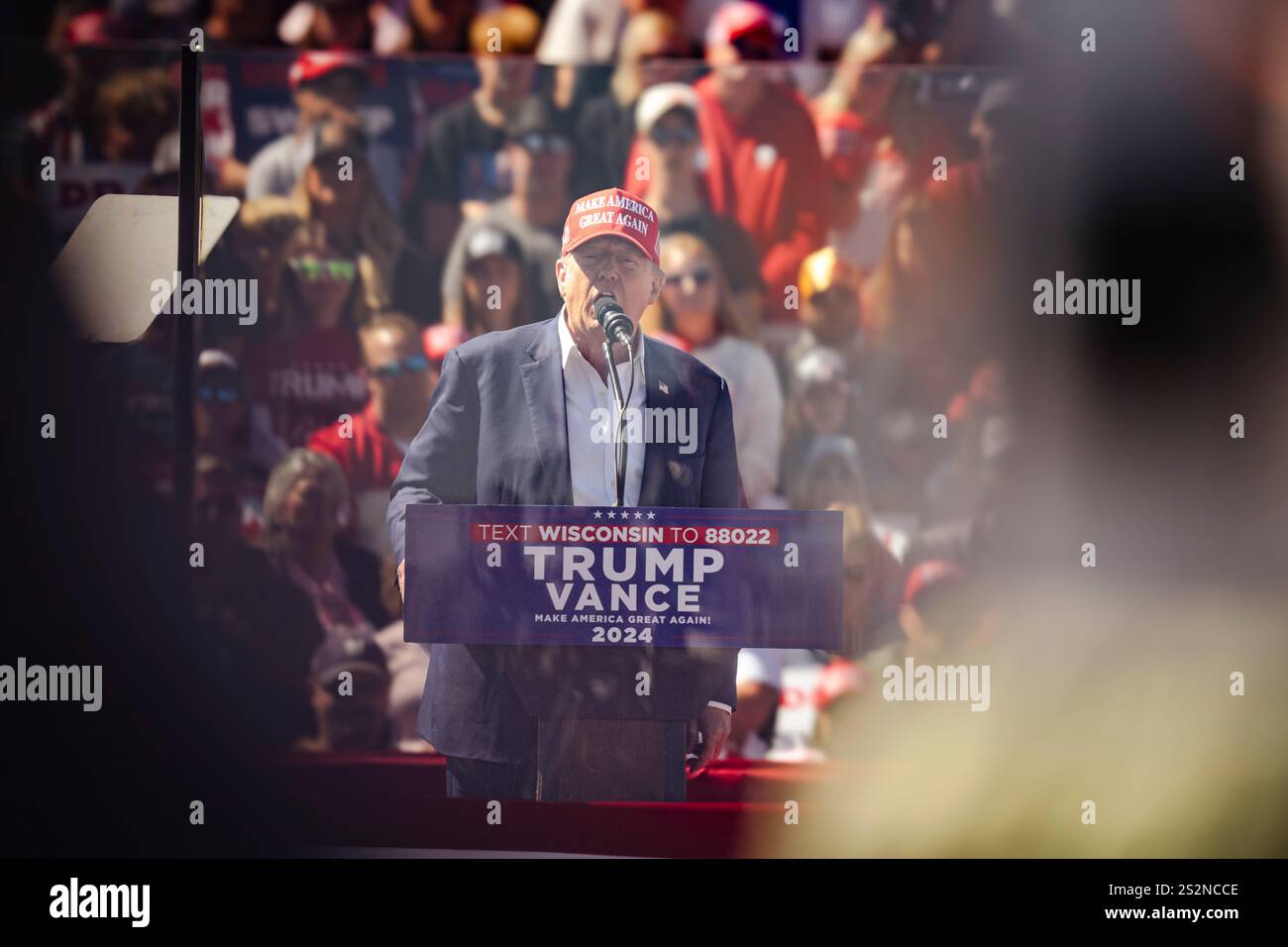 Donald Trump gives a speech behind bullet proof glass at an outdoor ...