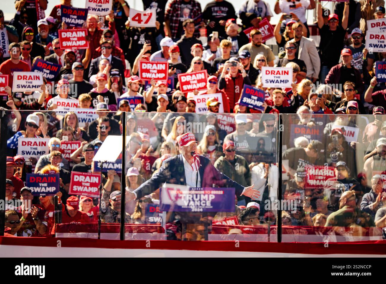 Donald Trump gives a speech behind bullet proof glass at a crowded ...