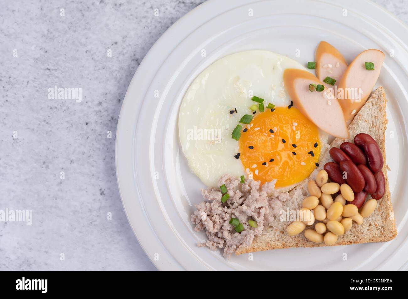 Breakfast consists of fried eggs, sausage, minced pork, bread, red ...