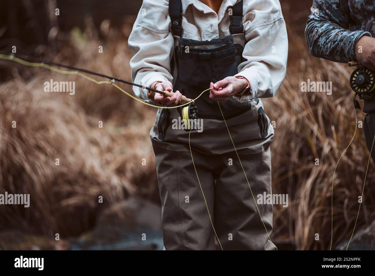 Woman holding fishing rod Stock Photo - Alamy