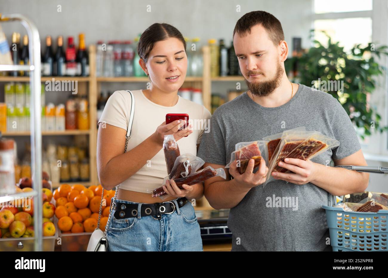 couple scans the QR code of meat products on their phone Stock Photo ...