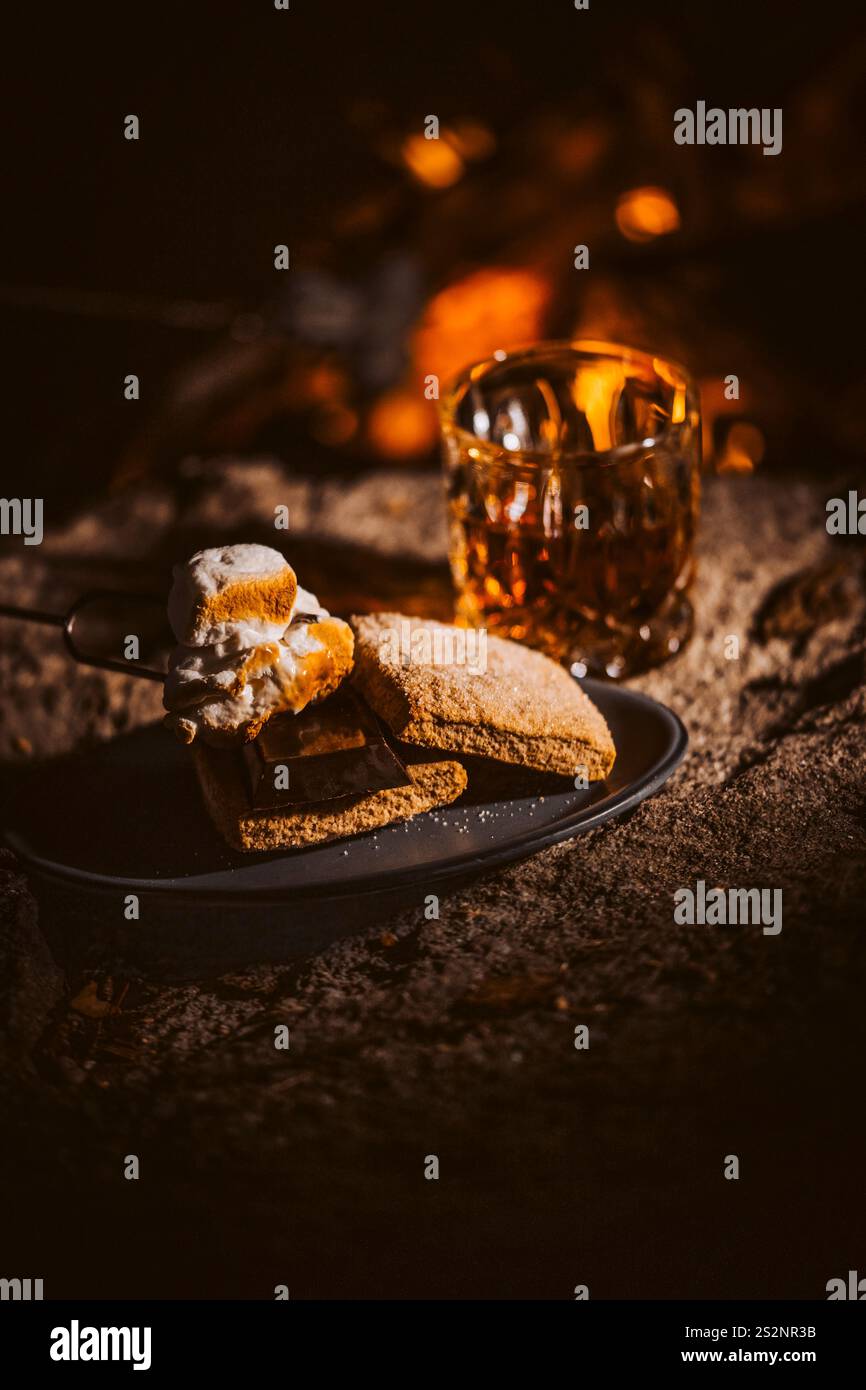 S'more against blurred fire pit and cocktail glass Stock Photo - Alamy