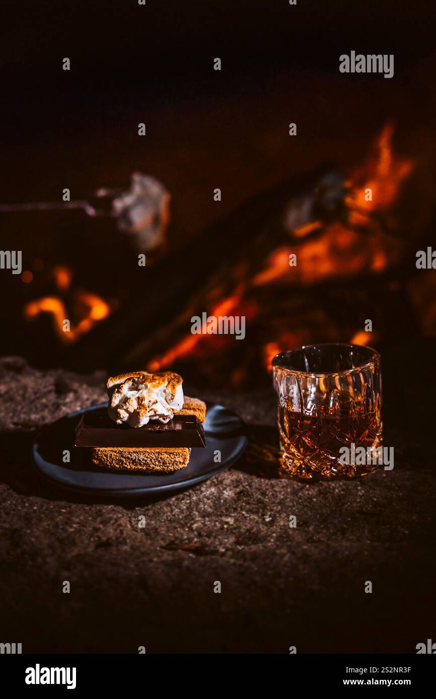 S'more against blurred fire pit and cocktail glass Stock Photo - Alamy