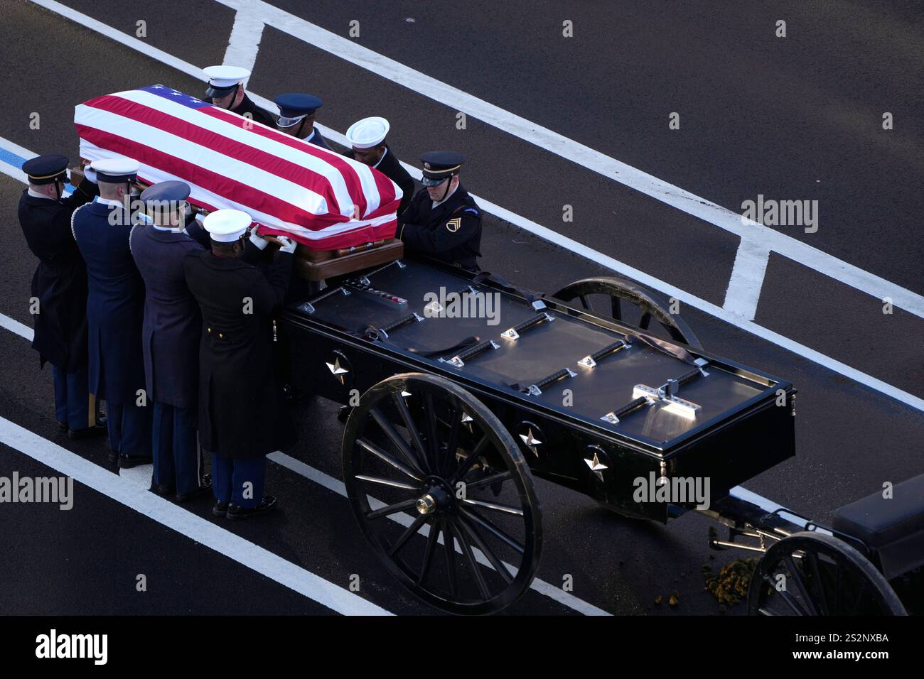 The flag-draped casket of former President Jimmy Carter is transferred ...