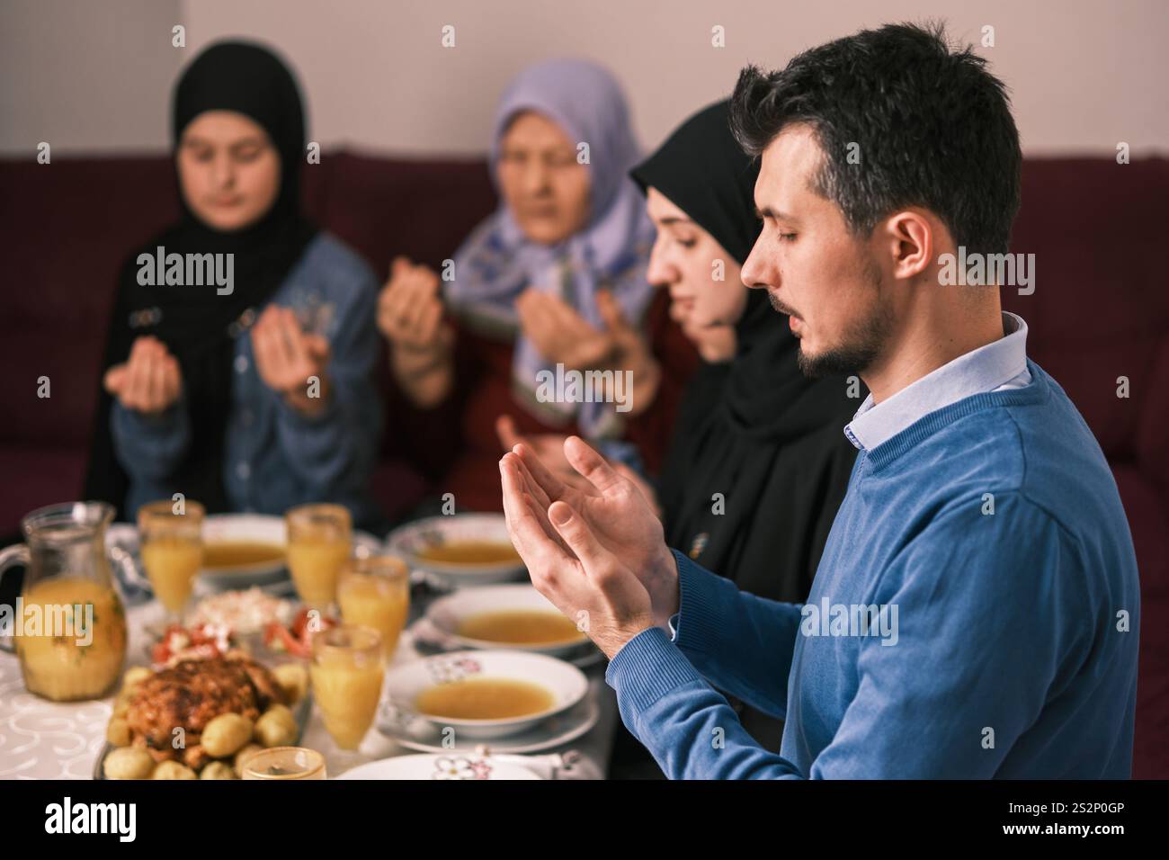 Muslim family making iftar dua to break fasting during Ramadan dining ...