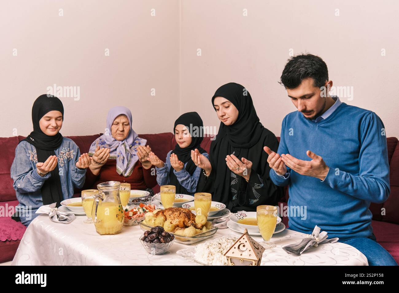 Happy Muslim family making iftar dua to break fasting during Ramadan ...