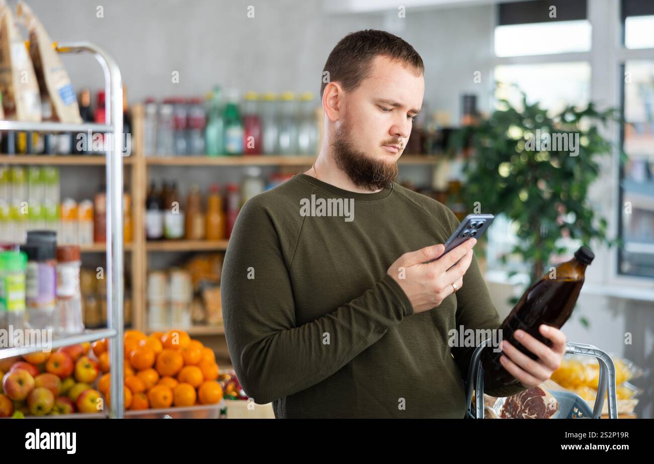 Male shopper scans QR code on the label of bottle pomegranate in ...