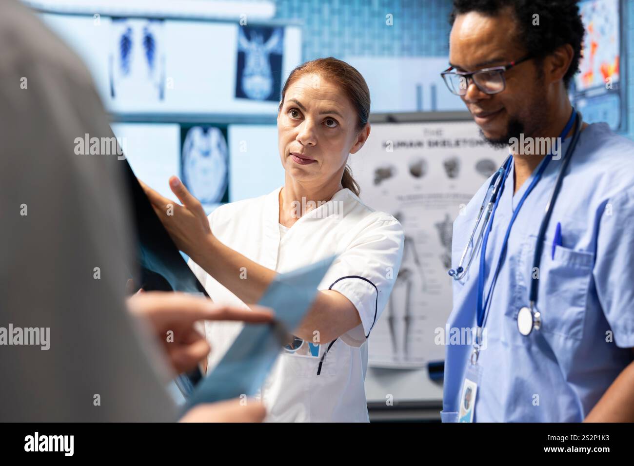 Healthcare team examines x ray results and discusses disease prevention during a meeting with ...