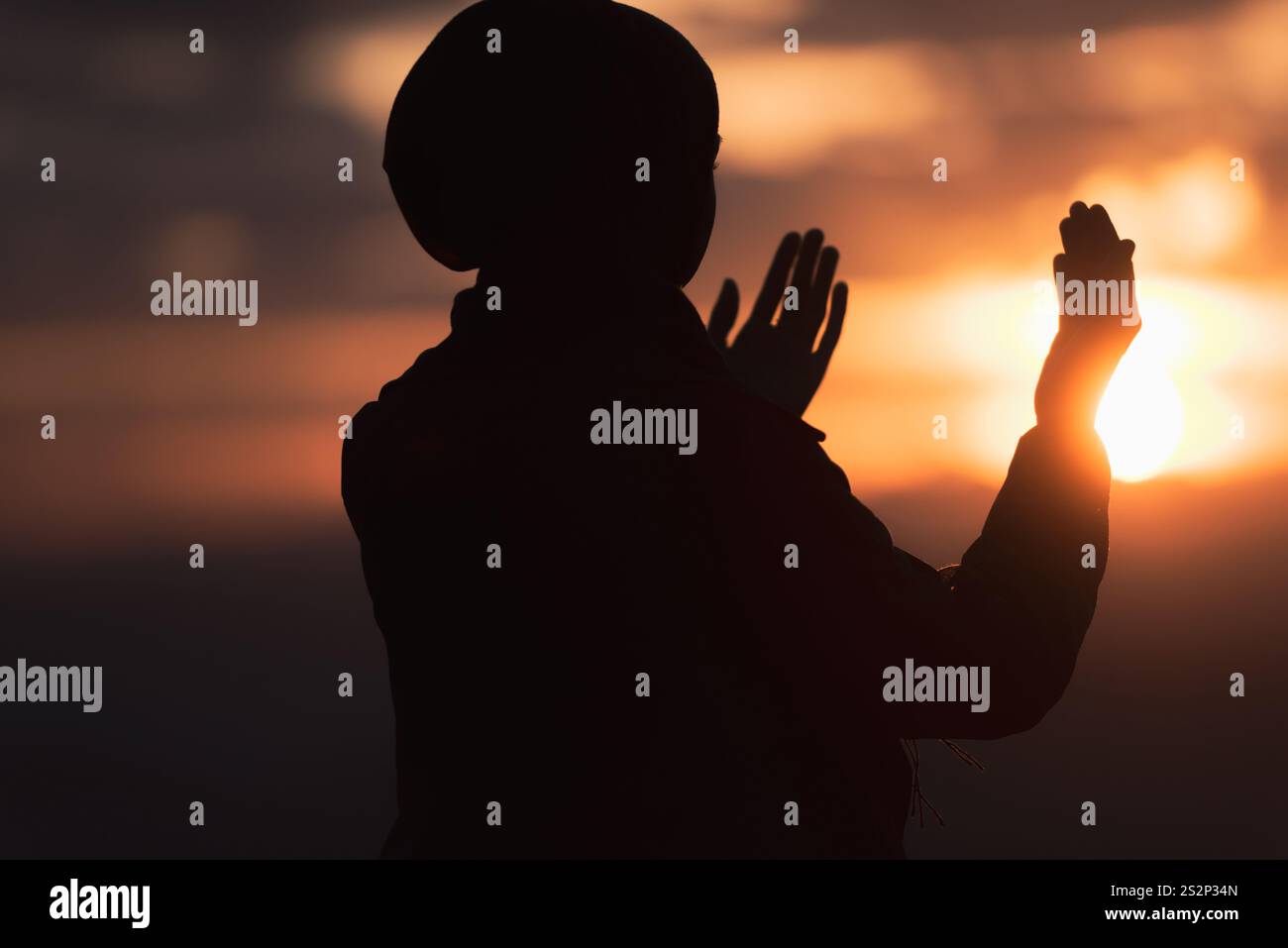 Muslim woman prayer praying with hands up open doing dua at sunset ...