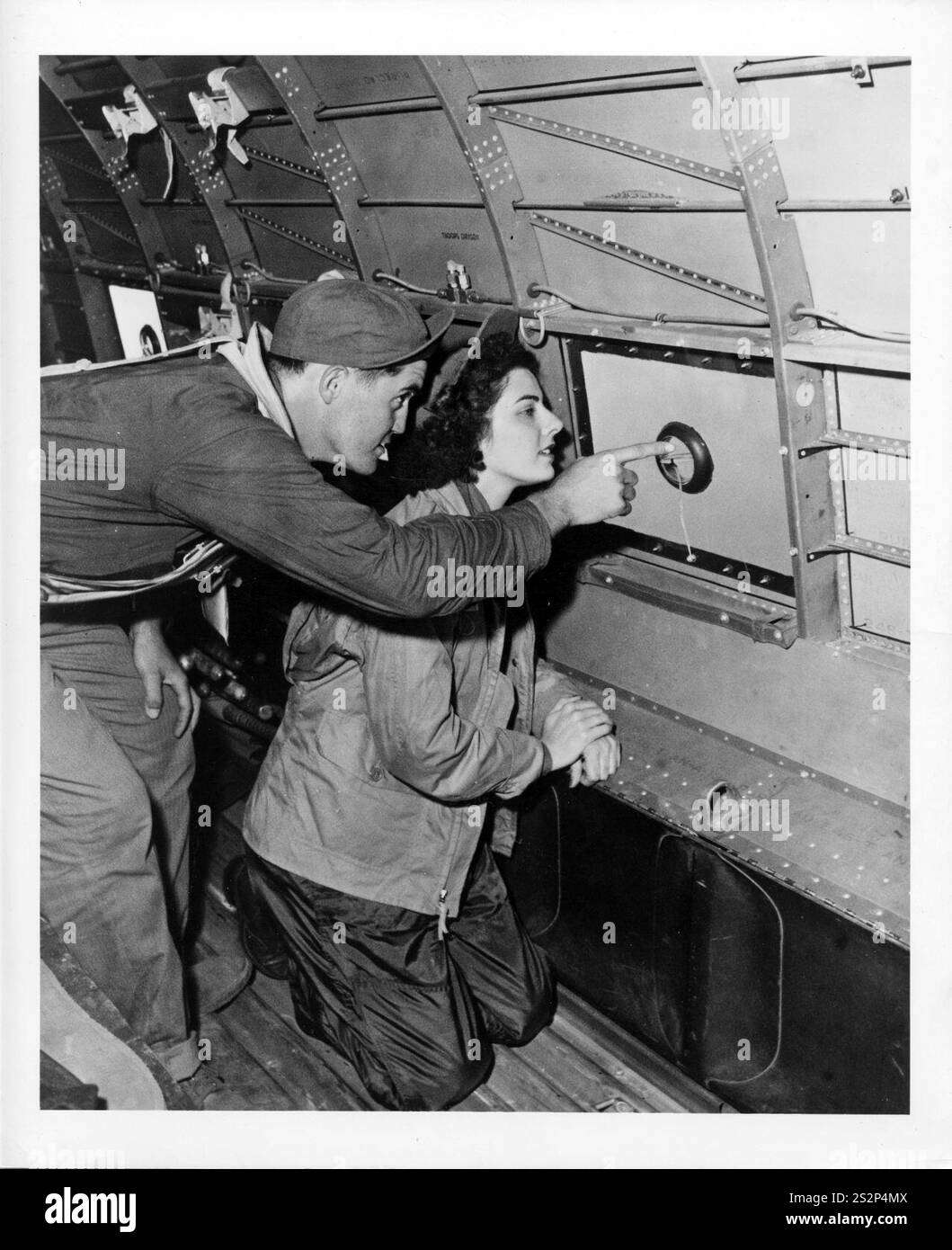 Flight nurse Jane Kendeigh peers through the porthole of an R4D ...