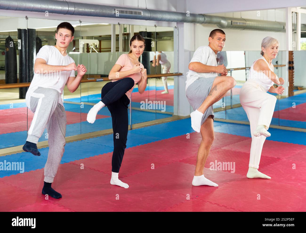 Group of adults practicing leg kicks in self defense training Stock ...