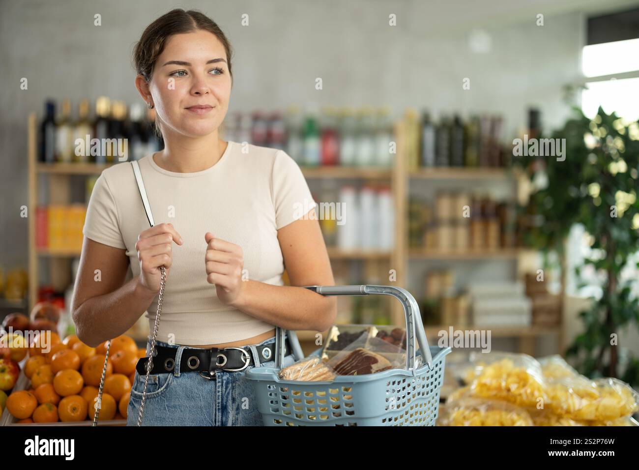 Visiting store, woman is looking at something on shelf of showcase ...