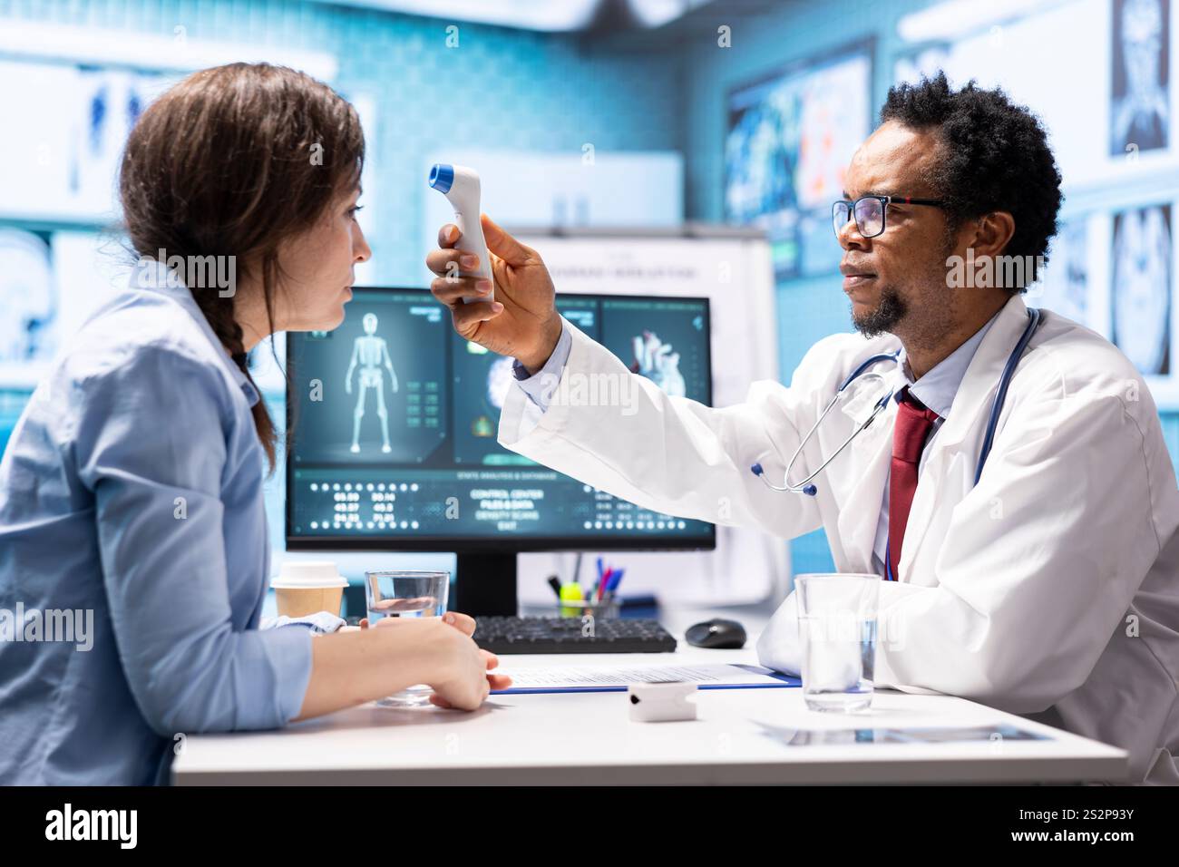 Doctor takes the temperature of his patient with a digital thermometer ...