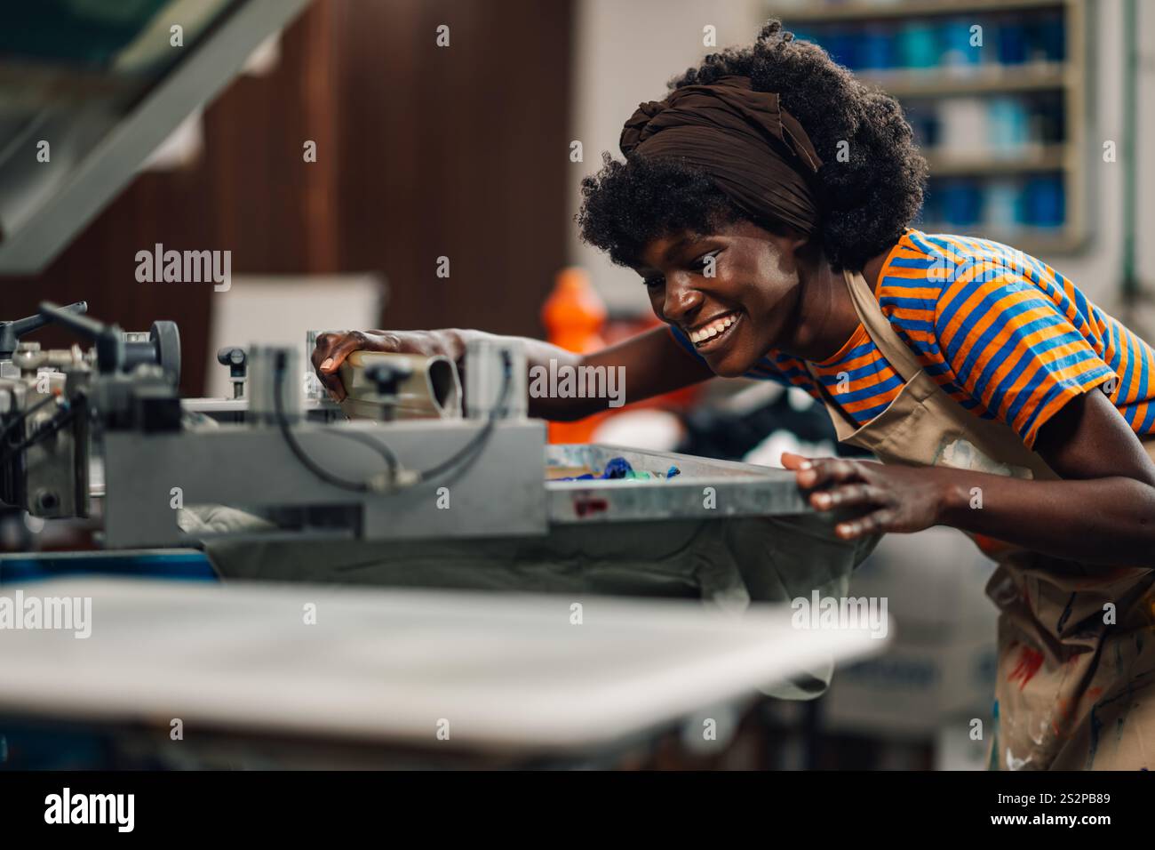 Smiling multicultural graphic technology expert is silk screen printing ...