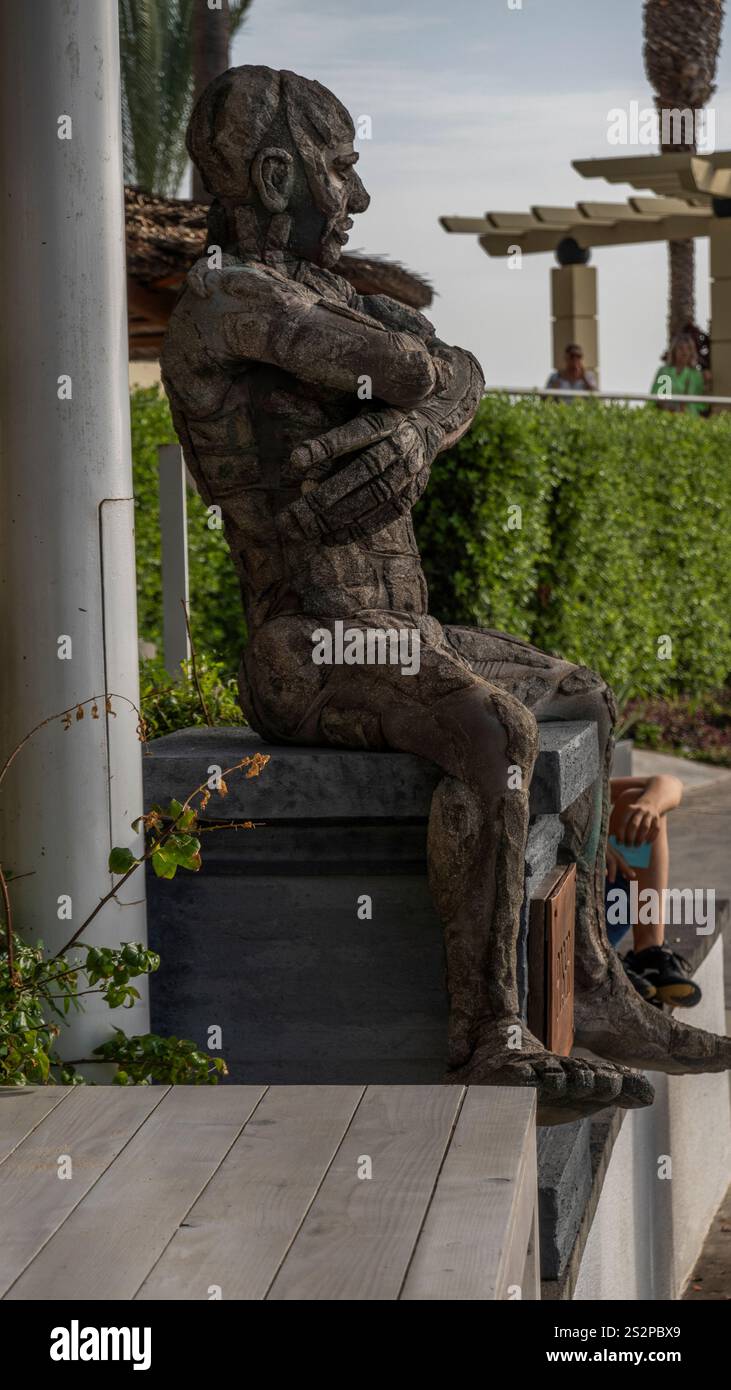 A detailed statue of a seated figure with crossed arms, made of ...