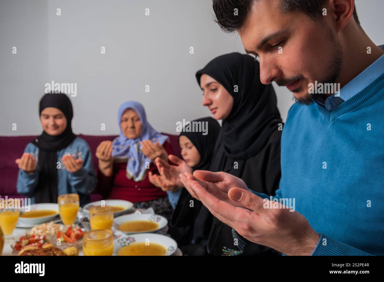 Muslim family making iftar dua to break fasting during Ramadan happy ...