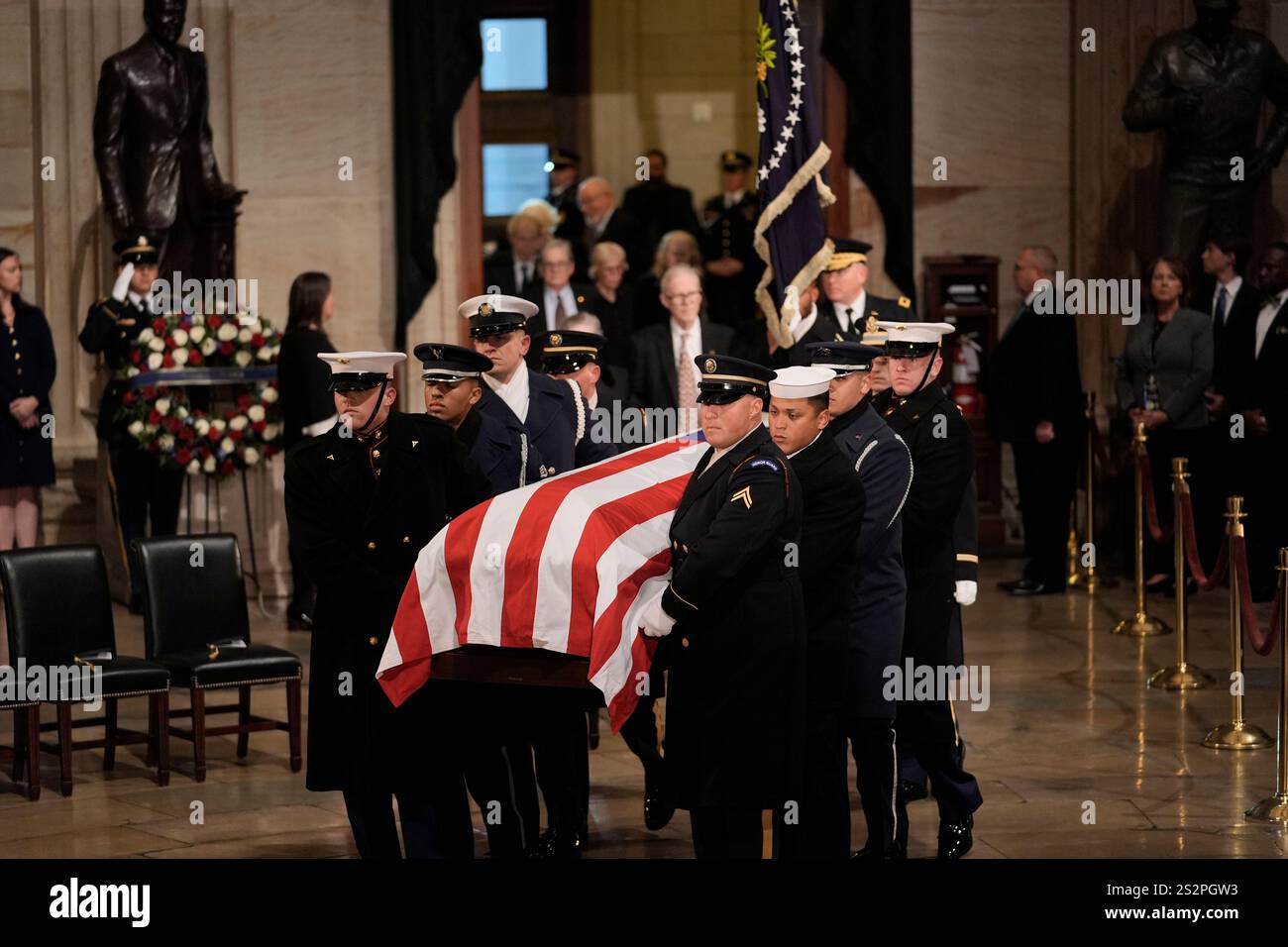 A joint services military honor guard carries the flag-draped casket of former President Jimmy ...