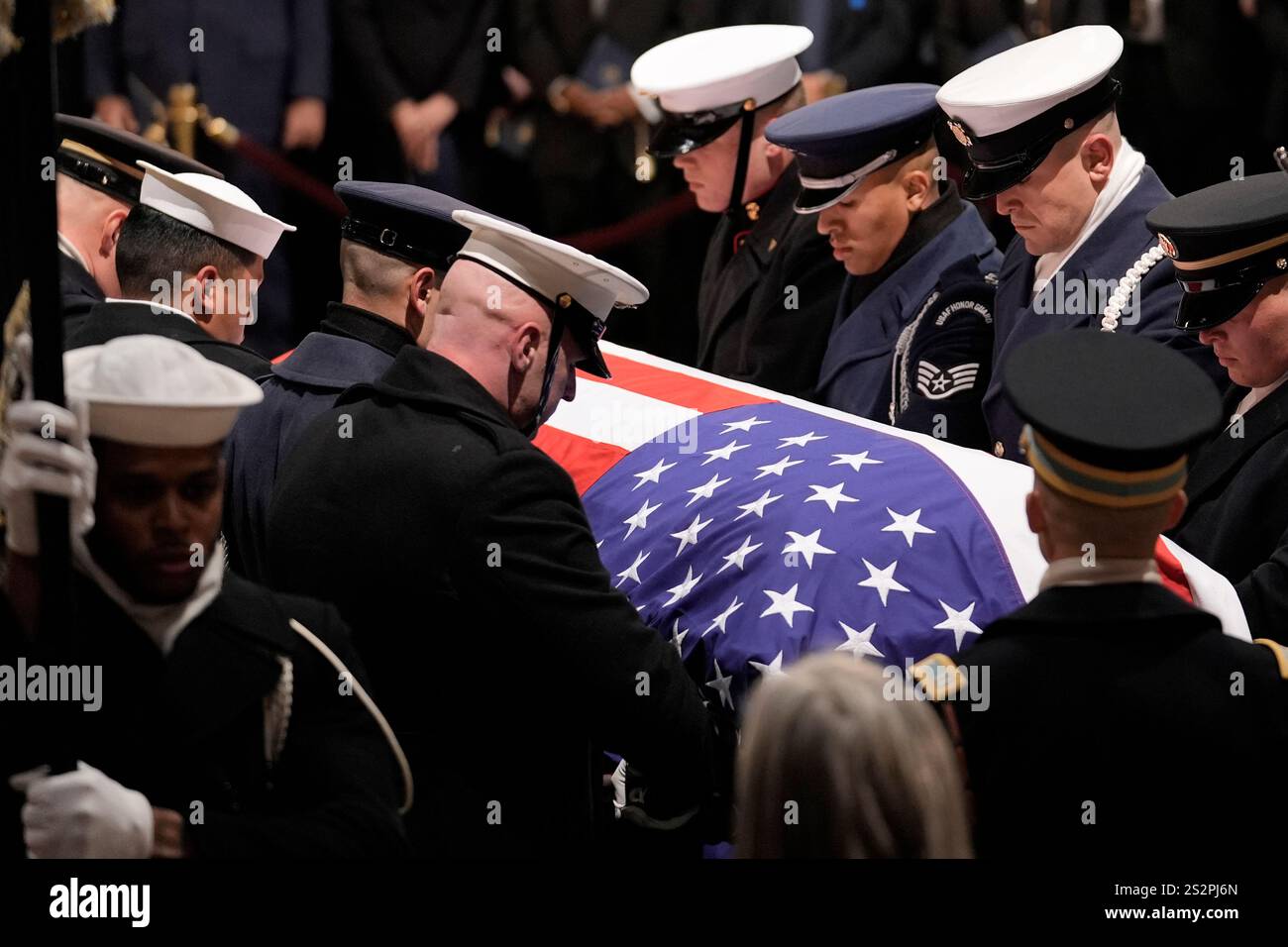 A joint services military honor guard carries the flag-draped casket of former President Jimmy ...