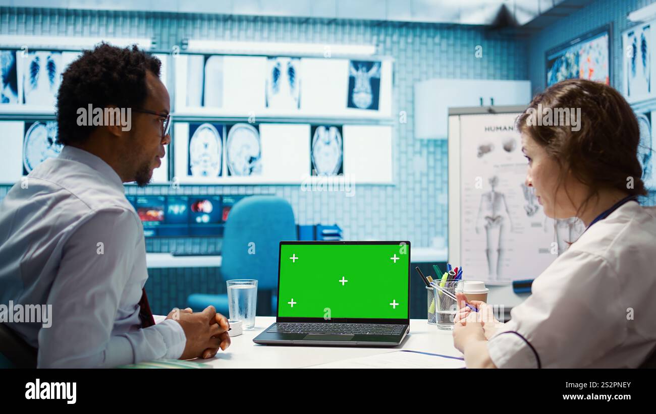 Doctor consulting a male patient in medical facility next to green ...
