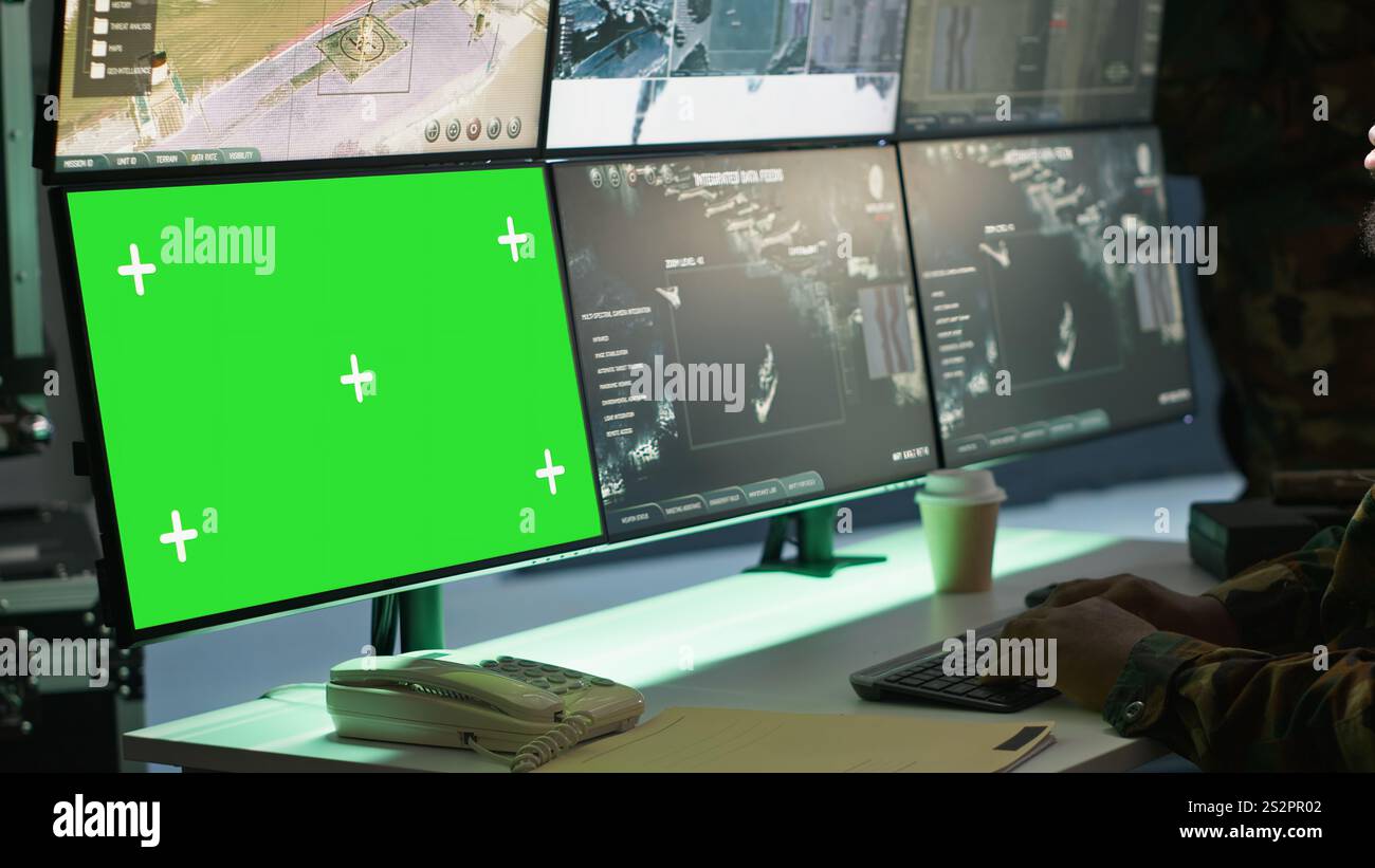 Air force officer performing tactical level surveillance in command room using mockup screen ...