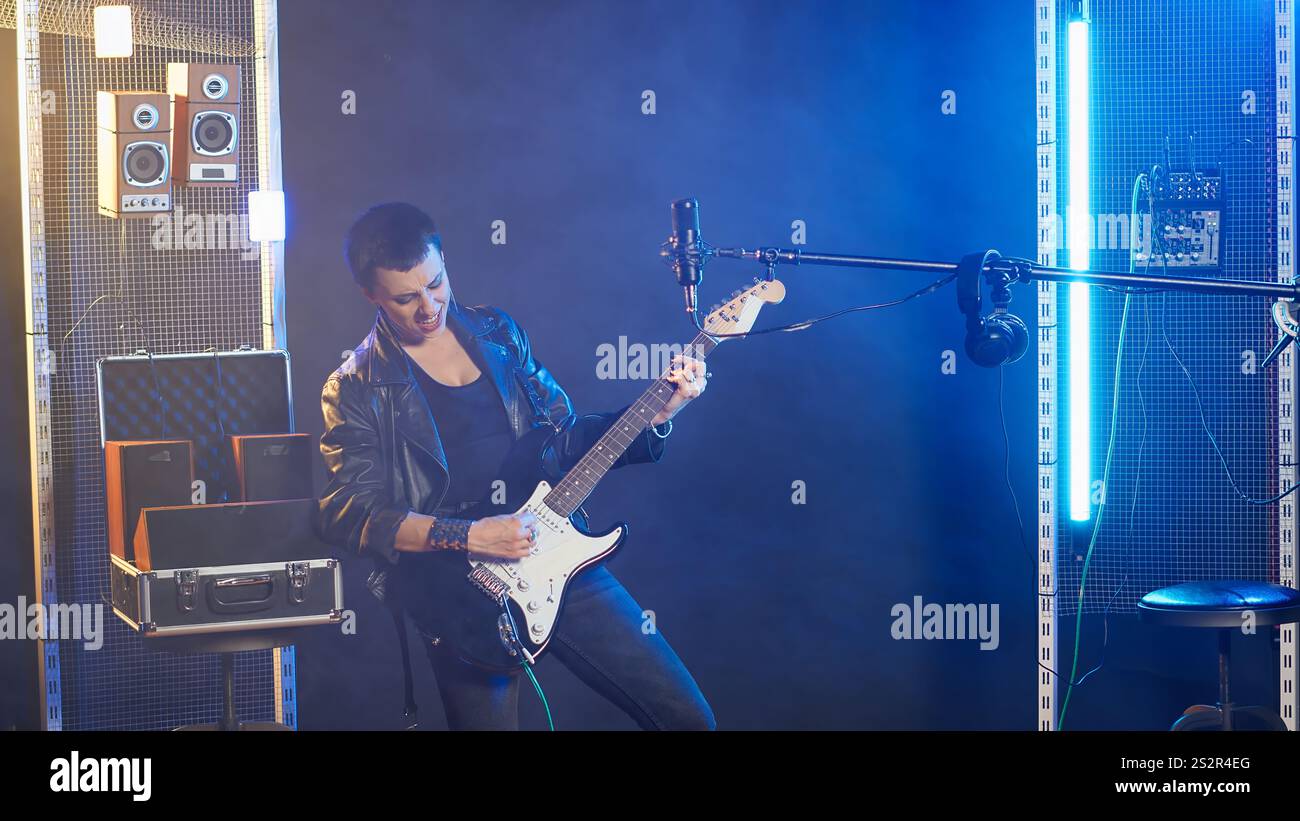 Woman rocker performing on electric guitar in a live show, delivering a ...