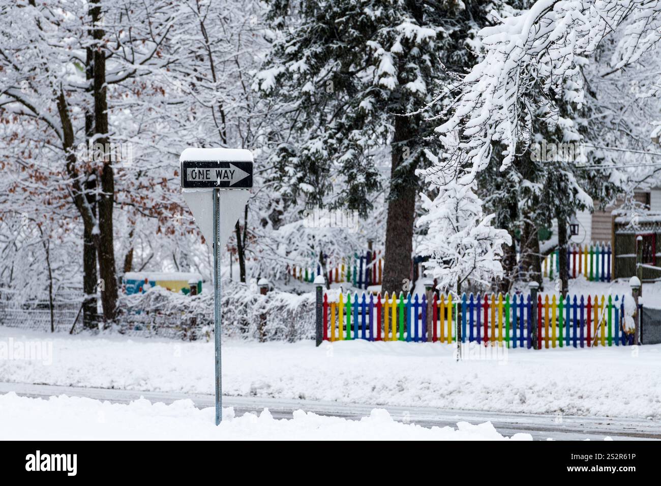 Street scene with "One-way" sign and a rainbow coloured fence covered ...