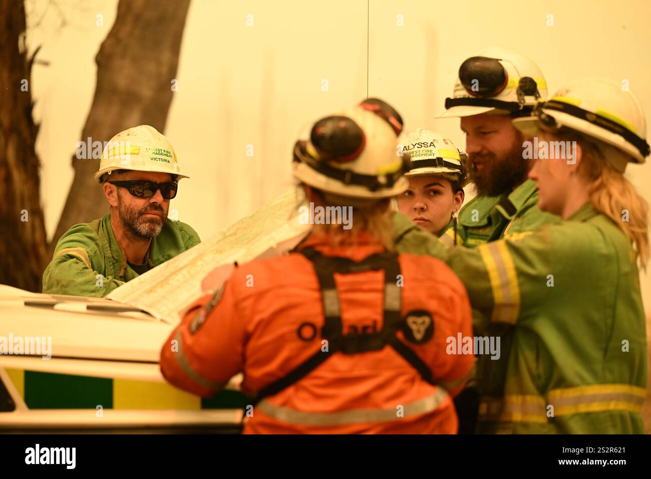 Forest Fire Management Victoria personnel are seen looking at a map on ...