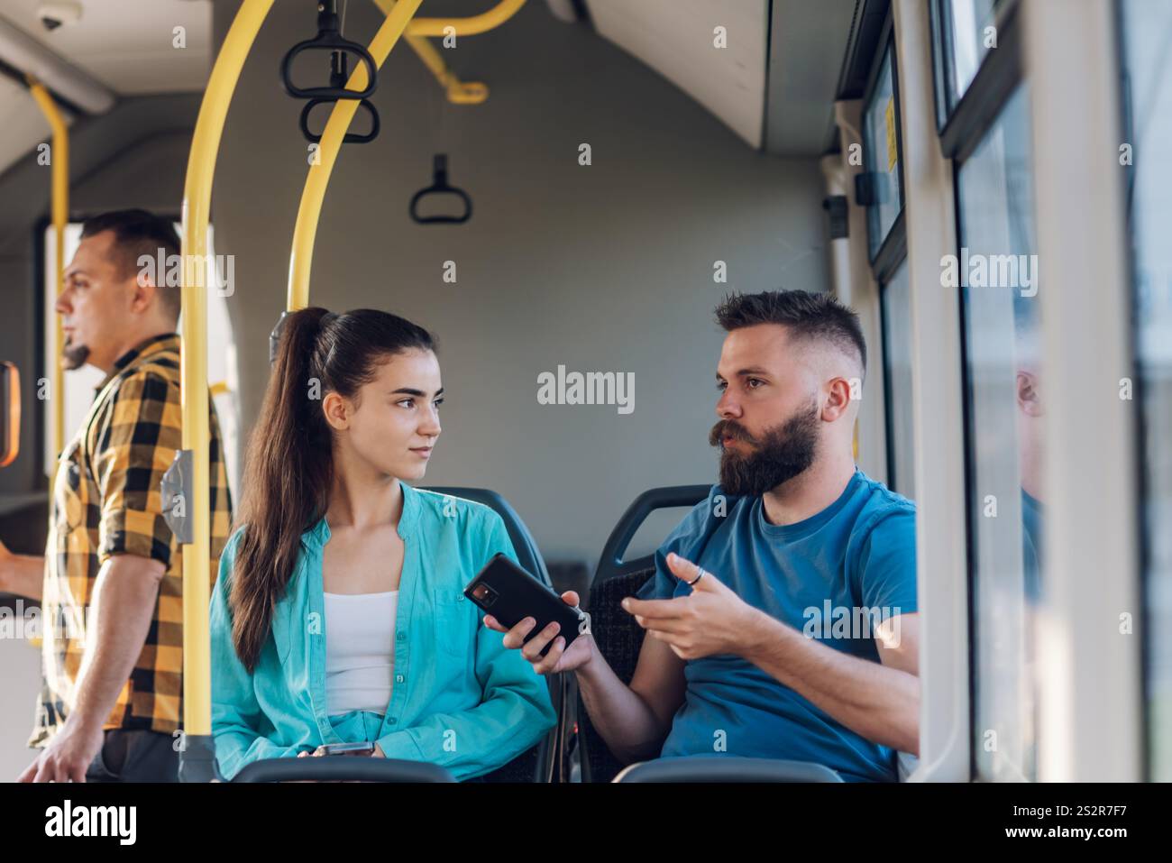 Cheerful friends smiling and talking together while riding in a bus in ...
