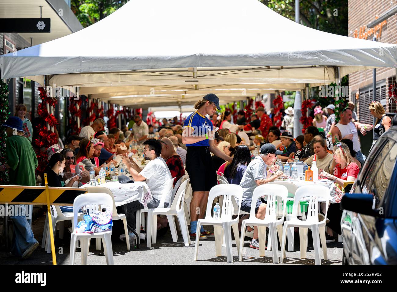 Members of the community attend the annual Christmas Street Party lunch ...