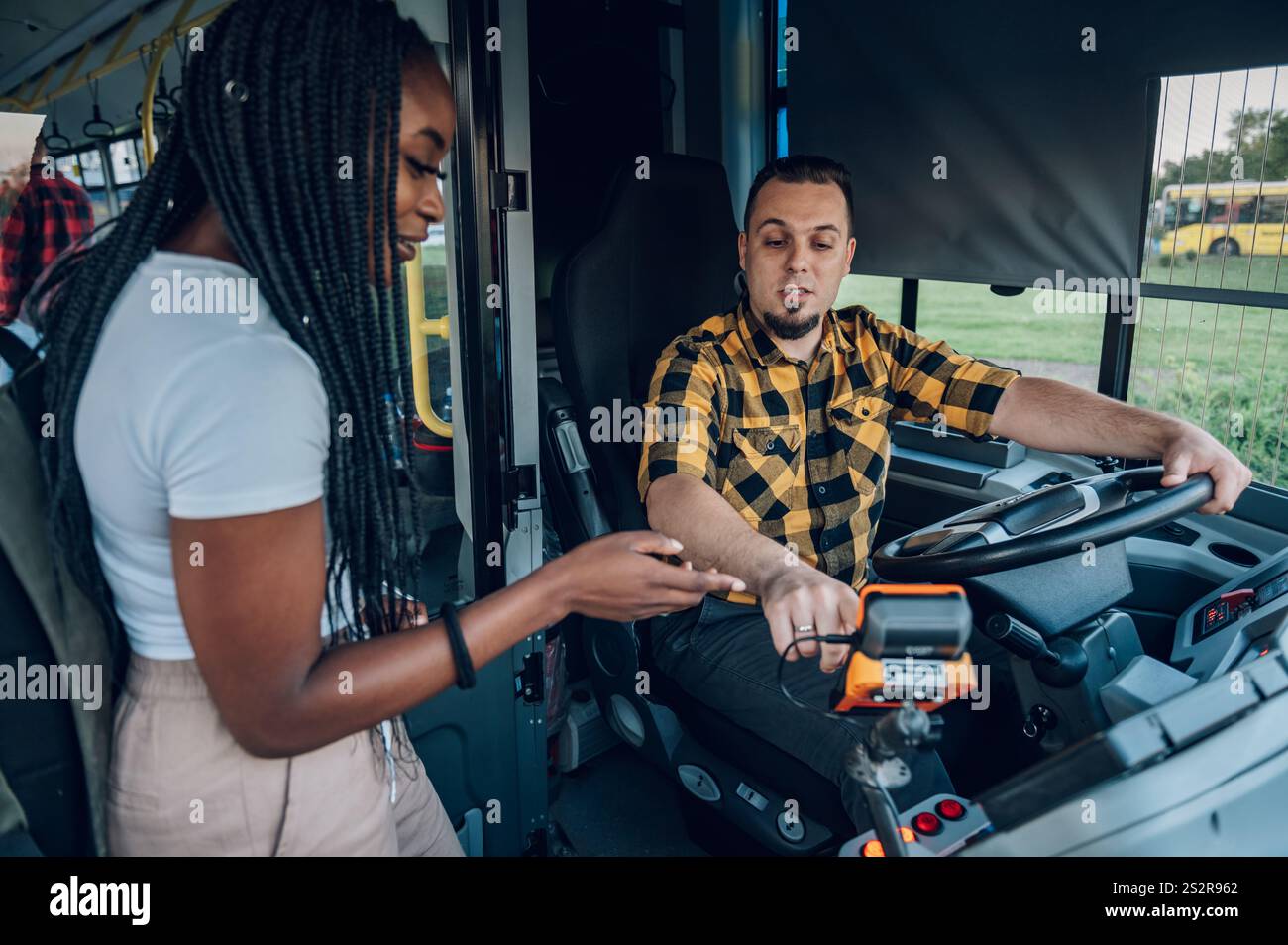 Professional bearded caucasian bus driver at steering wheel selling ...