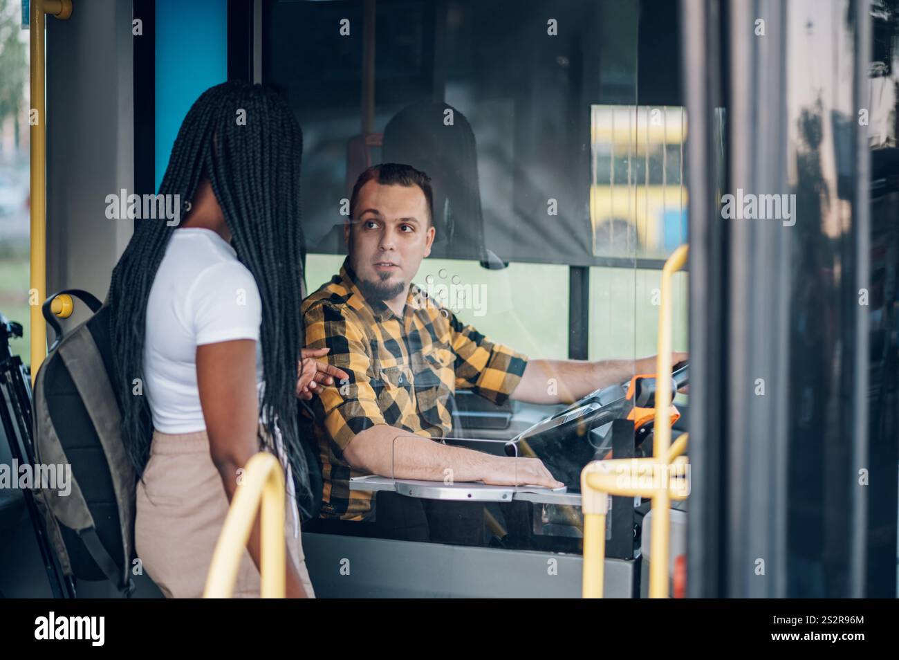 Professional bearded caucasian bus driver at steering wheel selling ...