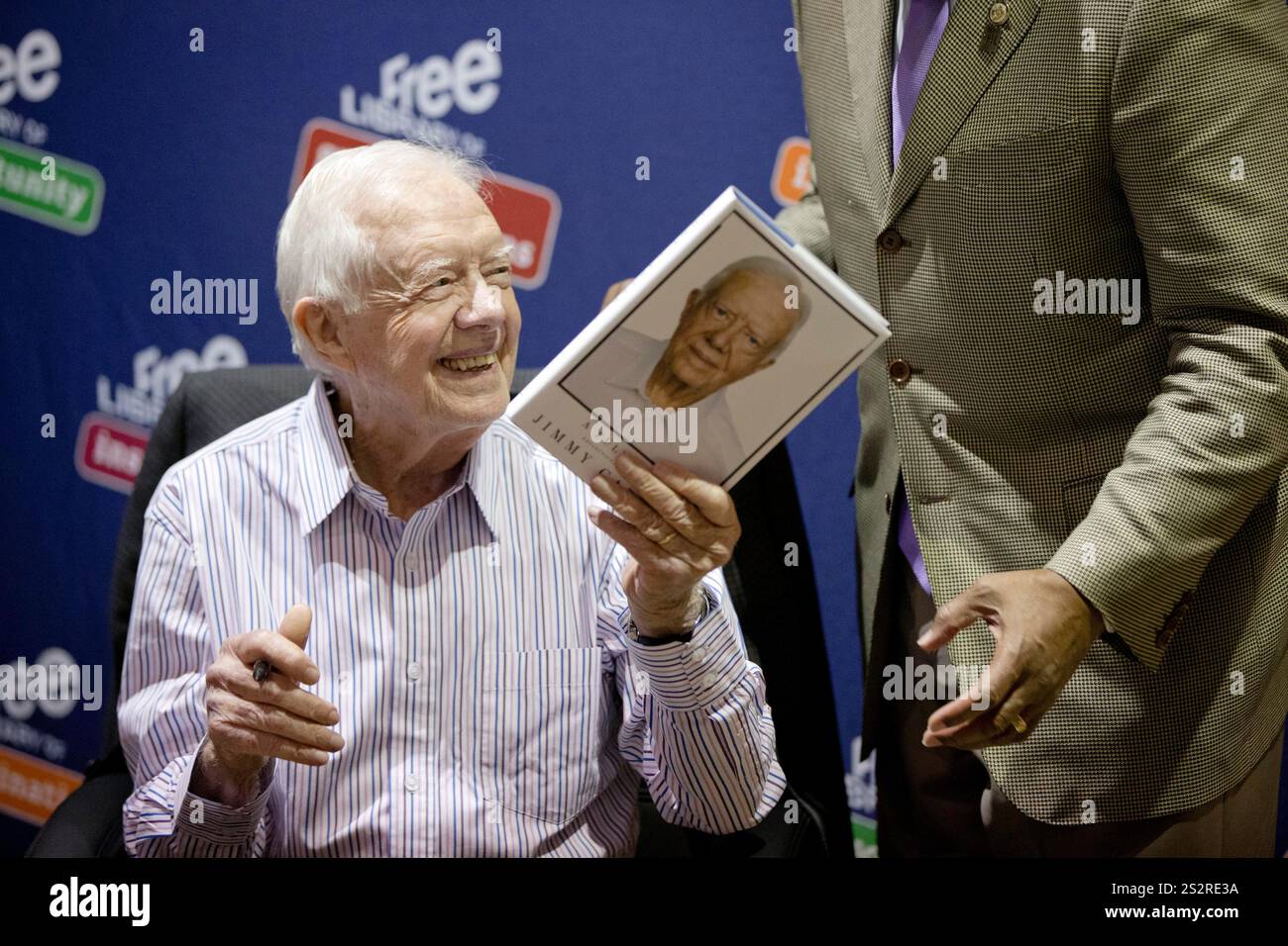FILE - Former President Jimmy Carter hands a copy of his new book, "A ...