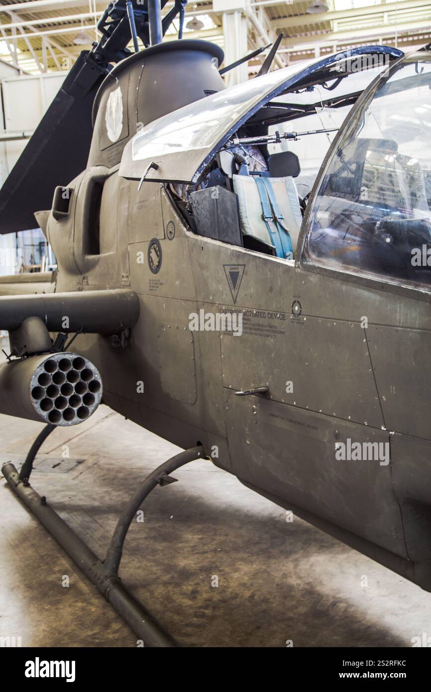 A military helicopter is on display in a hangar. The cockpit is open ...