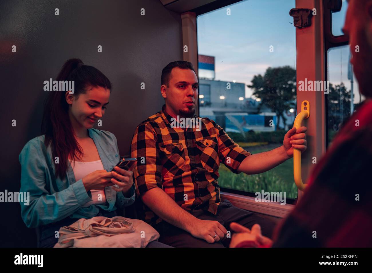 Diverse young friends laughing while sitting and talking together on a ...
