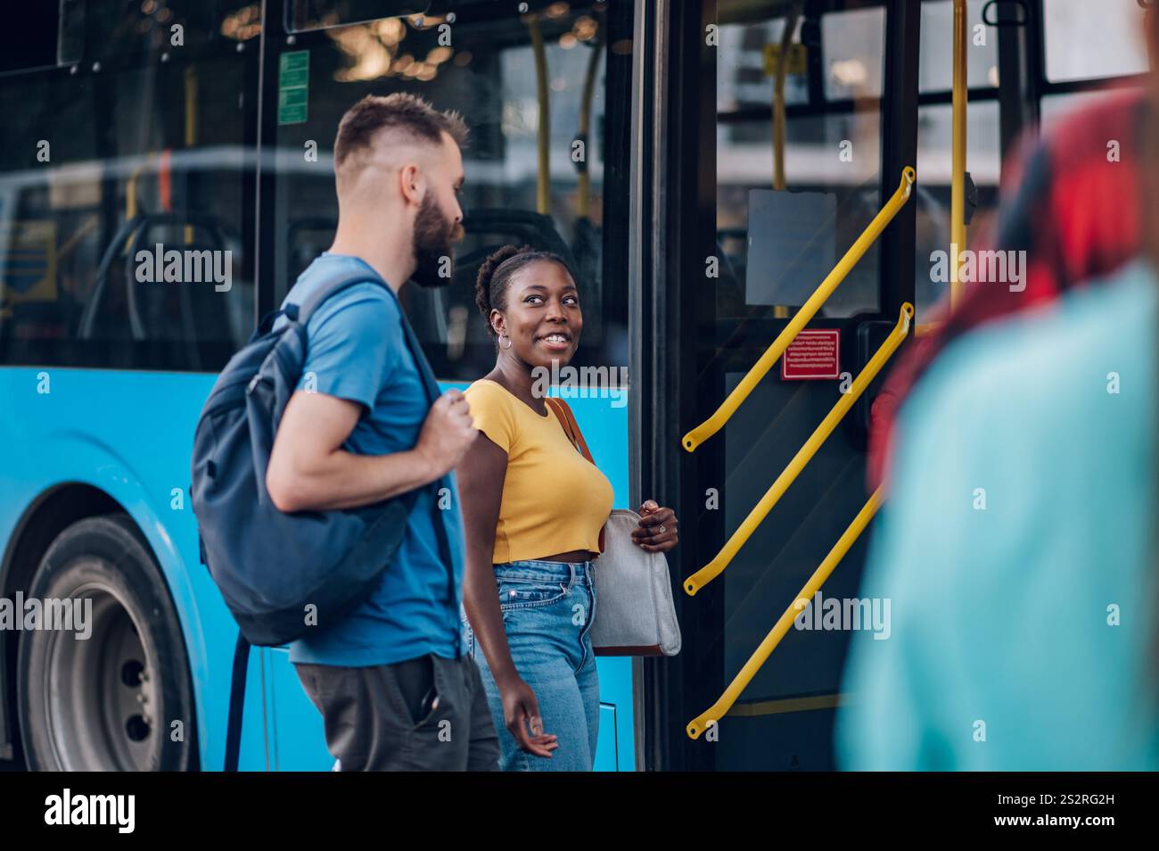Diverse group of friends waiting for a bus while at a bus stop. Riding ...