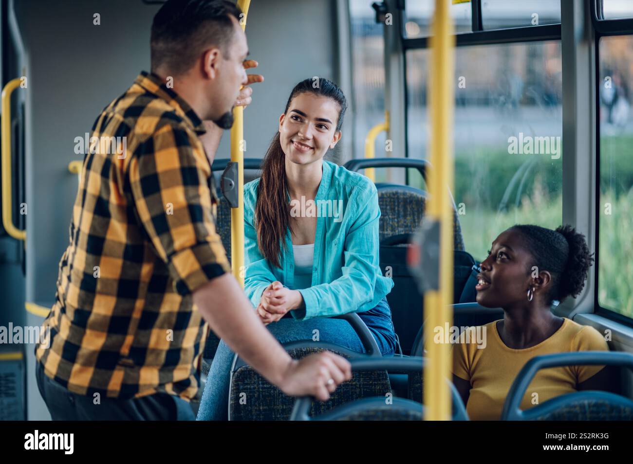 Multiracial smiling group of friends in a bus and talking while riding ...
