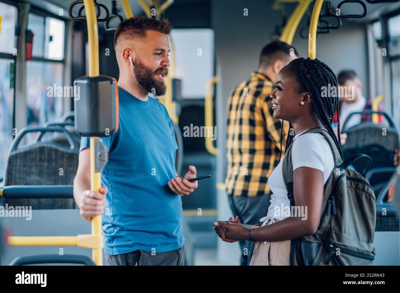 Smiling multiracial friends having fun while commuting together by a ...