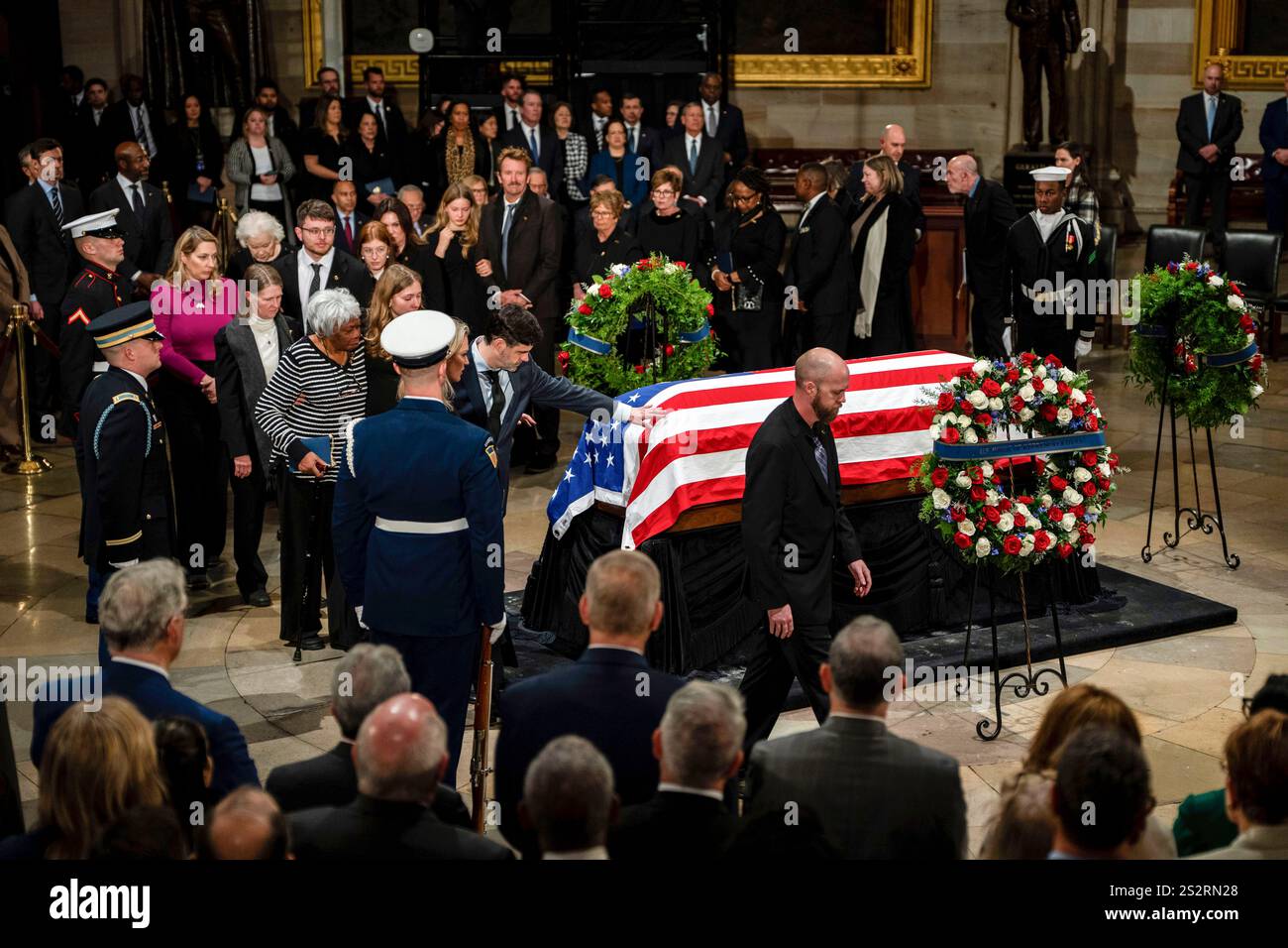 The Carter family pay their respects during a ceremony as the flag ...