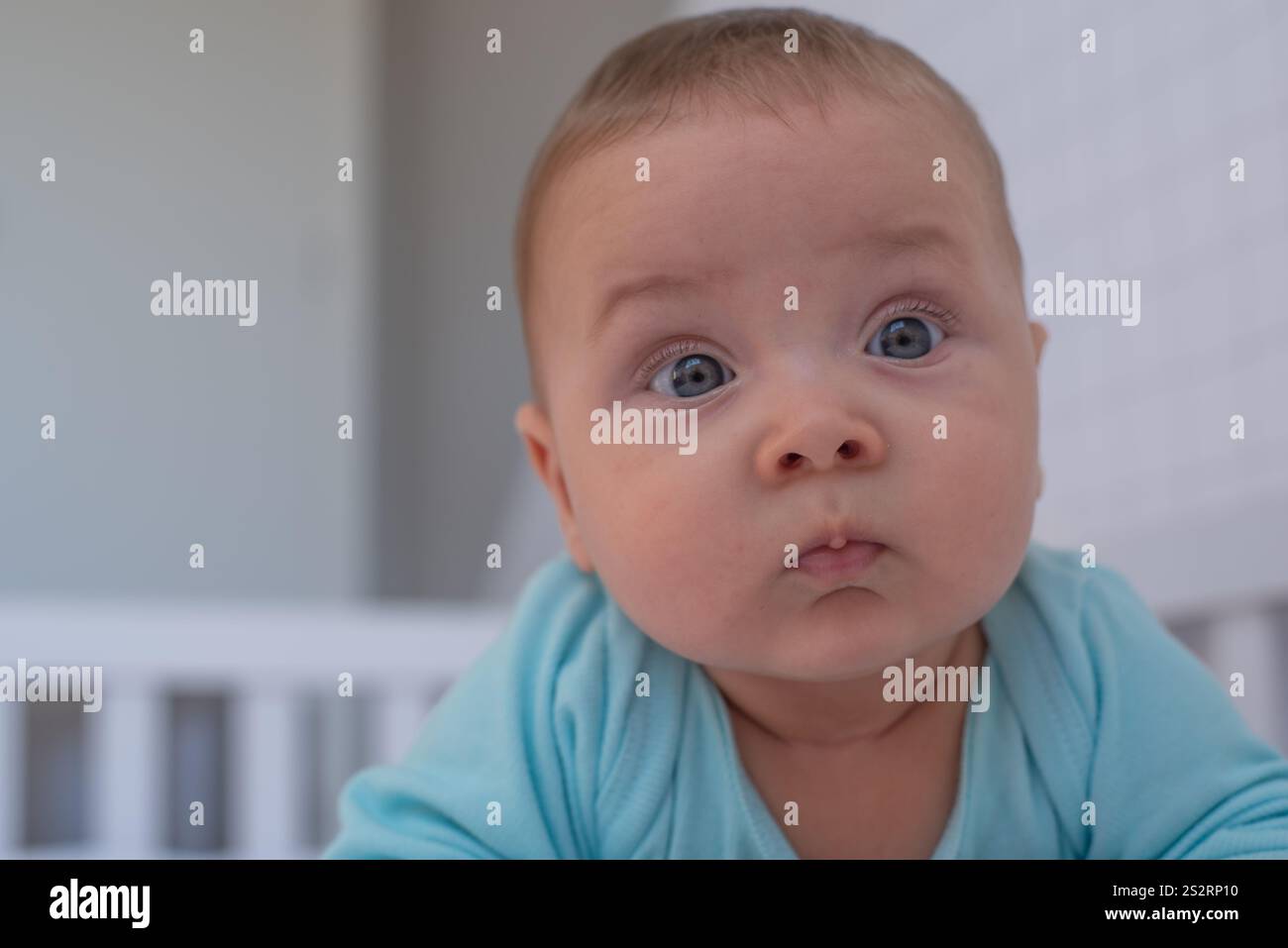 Baby lying on his stomach waking up Stock Photo - Alamy