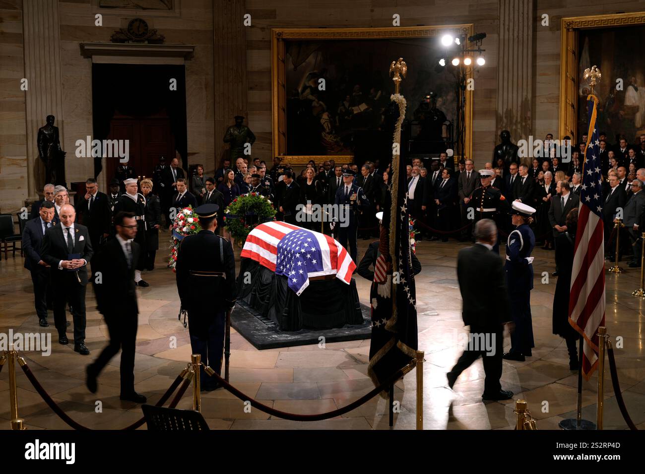 Guests pay their respects as the flag-draped casket of former President ...
